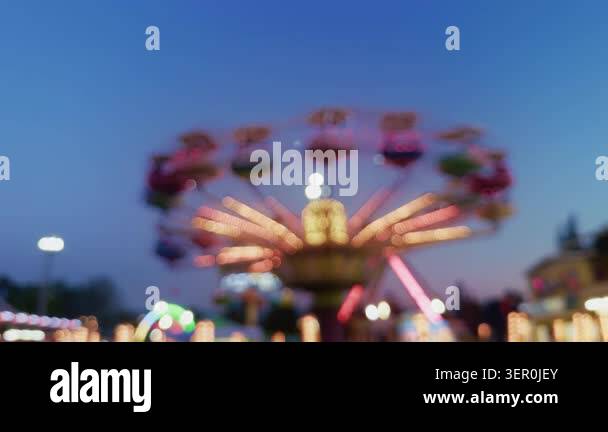 Defocused out of focus shot of spinning amusement park rides during ...