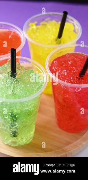Colorful fruit slushies rotating on purple and black background Stock ...