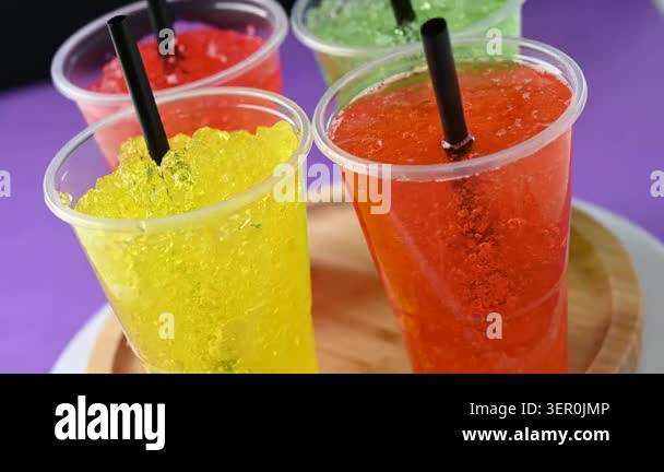 Colorful fruit slushies rotating on purple and black background Stock ...