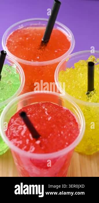 Colorful fruit slushies rotating on purple and black background Stock ...