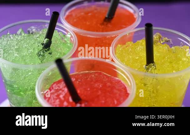 Colorful fruit slushies rotating on purple and black background Stock ...