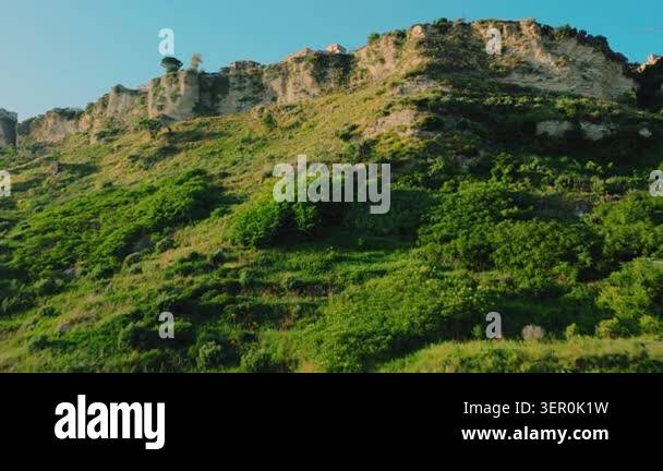 Climbing towards the medieval village of Gerace from a steep cliff ...