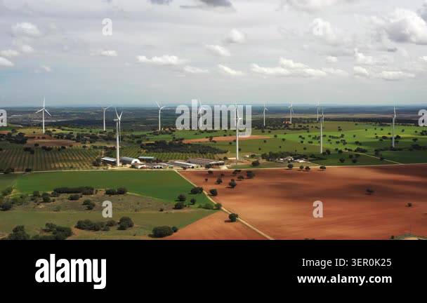 High above a stunning landscape, rows of wind turbines spin gently in ...