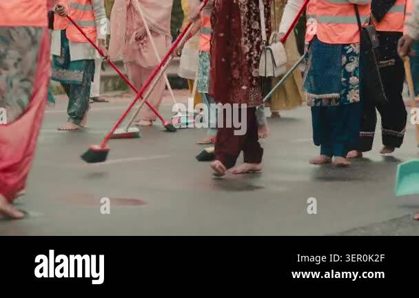 Women clean the road for the Indian Vaisakhi procession Stock Video ...