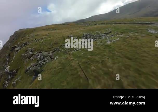 Immersive fpv drone perspective flying fast and low along a rugged ...