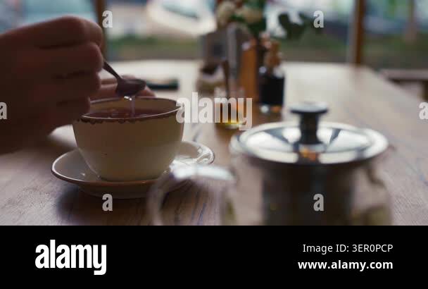 Relaxed morning scene with a person drinking tea in a cozy cafe Stock ...