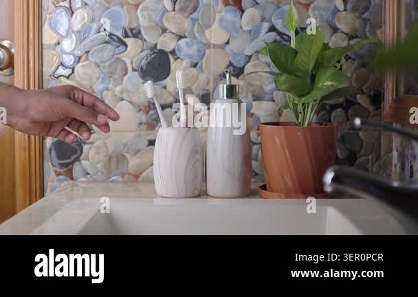 Hand Picking Up a Toothbrush from a Holder in a Bathroom Stock Video ...