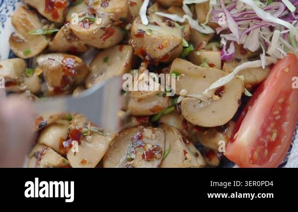 Cook is preparing mushrooms with sauce and herbs at market stall Stock ...