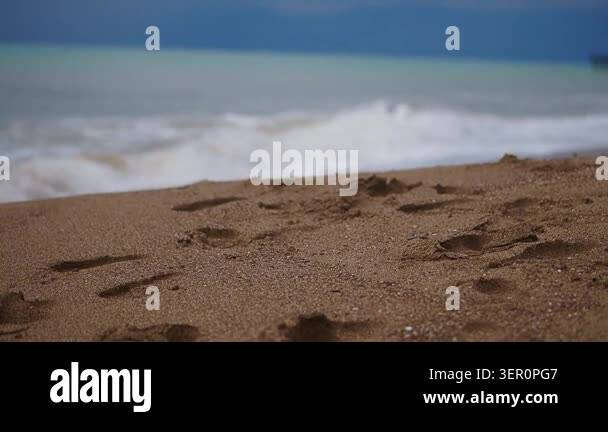 People walk along the beach and leave footprints in the sand Stock ...