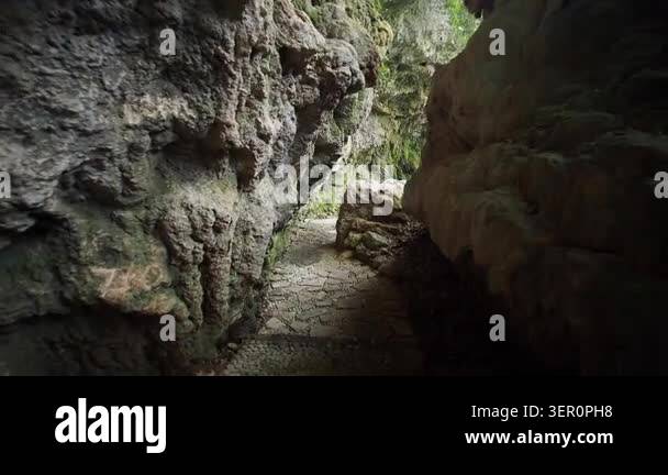 Watch as people walk along a narrow path between tall rocks Stock Video ...