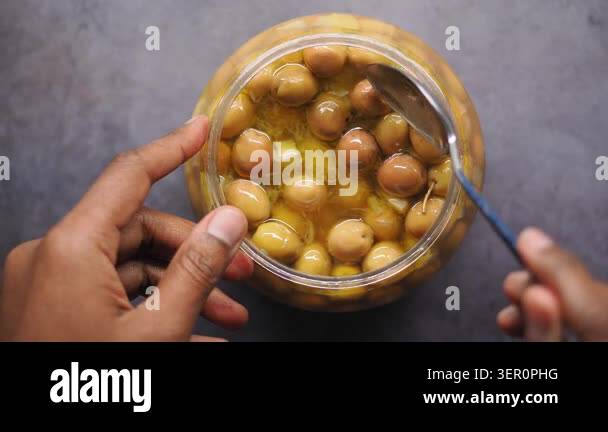 A person prepares pickled olives inside a glass jar Stock Video Footage ...