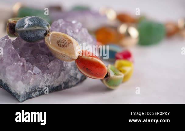 Beads in various colors are shown next to colorful stones Stock Video ...
