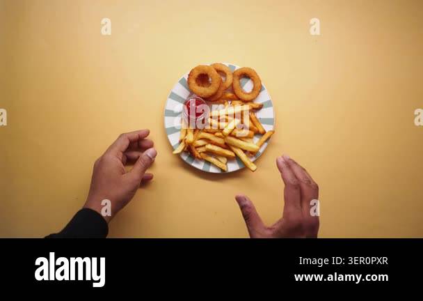Hands are reaching for onion rings and fries with ketchup Stock Video ...