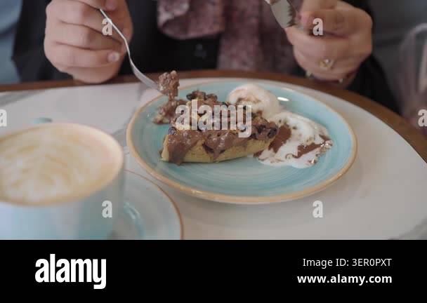 Person tastes dessert with ice cream and drinks coffee at a cafe Stock ...