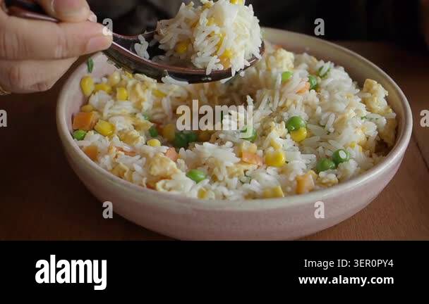 Person eats fried rice with mixed vegetables and eggs at home Stock ...