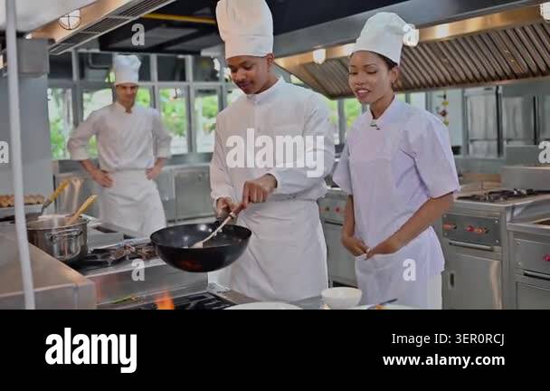 Professional senior chef instructor observe young male student cooking ...
