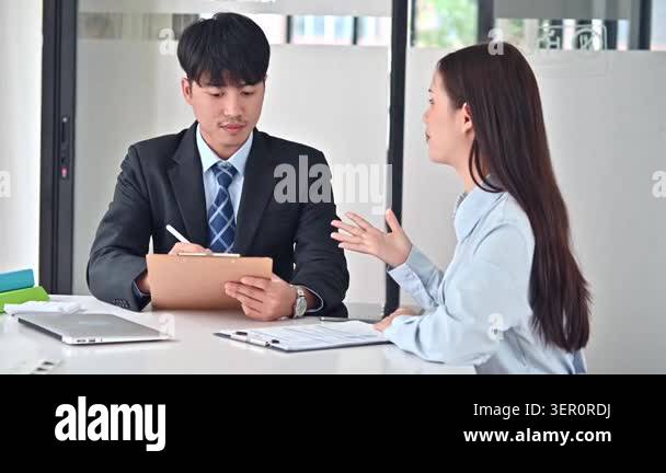 Smiling male manager hold clipboard during job interview with female ...