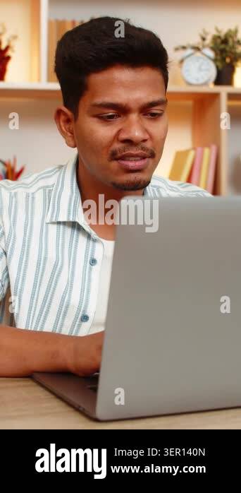 Indian man on home table closes laptop with satisfied smile after ...