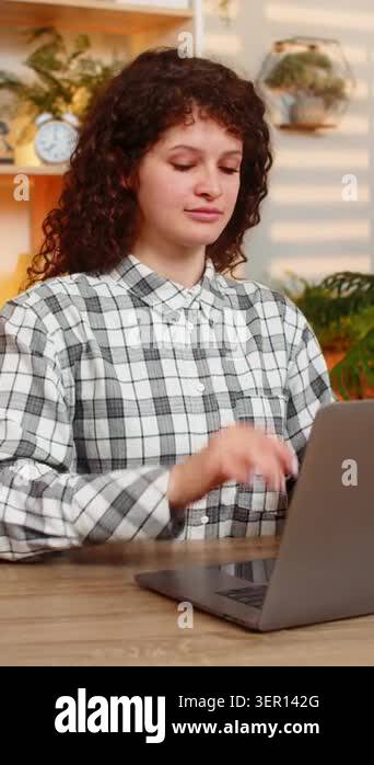 Young woman on home table opens laptop and starts remote work with calm ...