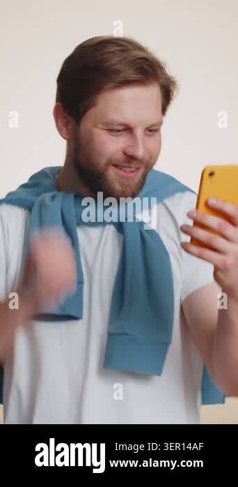 Happy amazed excited joyful Caucasian man in t-shirt use smartphone ...