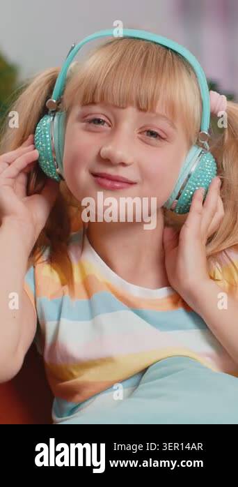 Happy overjoyed toddler lady kid in wireless headphones relaxing ...