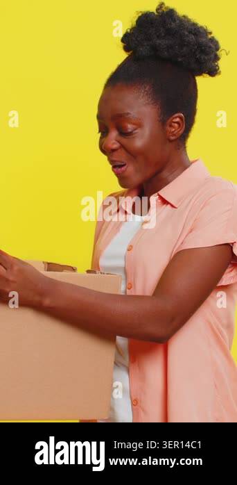 African American woman opens cardboard box, showing excitement joy ...