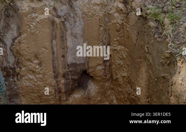 Workers drill a well in muddy ground to find water. The process ...