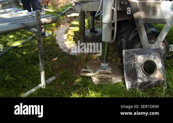Workers drill a well to access underground water. The equipment is set ...
