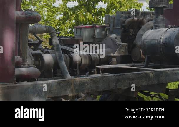 Workers operate a drilling machine in a rural area to access ...