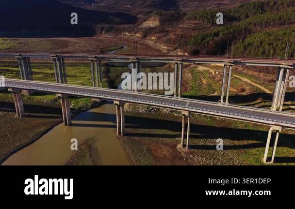 Two bridges cross over a river in a rural valley. The scene shows green ...