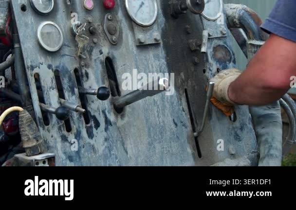 A worker operates drilling equipment used to create a water well in a ...