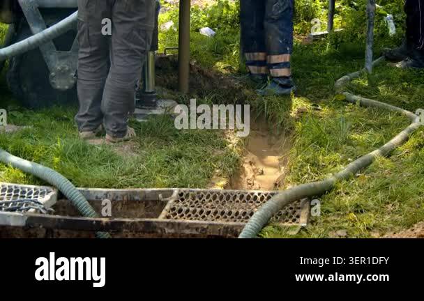 Workers are drilling at a site where a well is being created. Water is ...