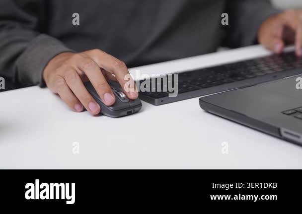 This image captures a close-up of a programmers hand using a mouse and ...