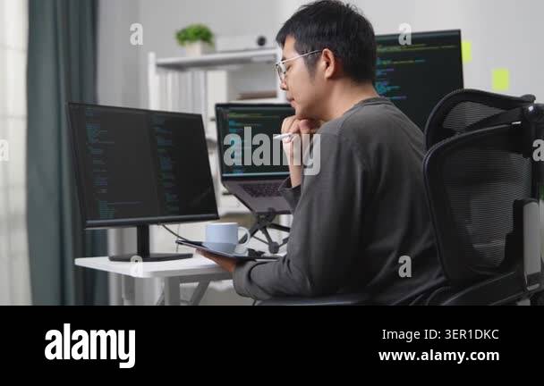 A programmer is intently working on multiple screens showcasing code ...