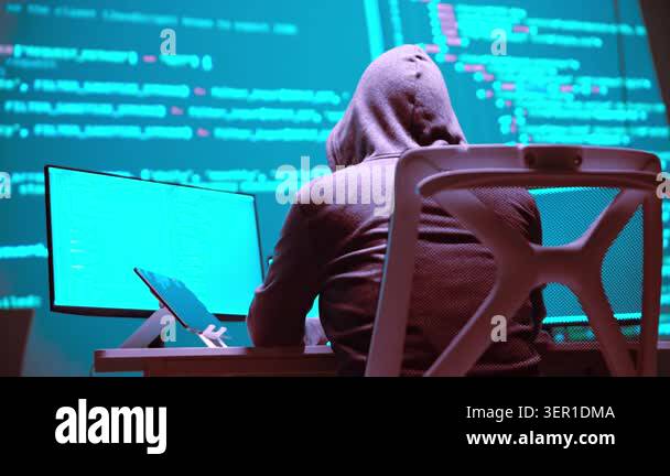 A hacker is seen typing at a computer, with lines of code displayed on ...