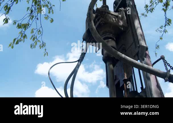 Workers are using a drilling machine to create a water well. The scene ...