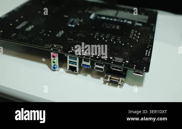 Hands carefully install a component onto a black computer motherboard ...
