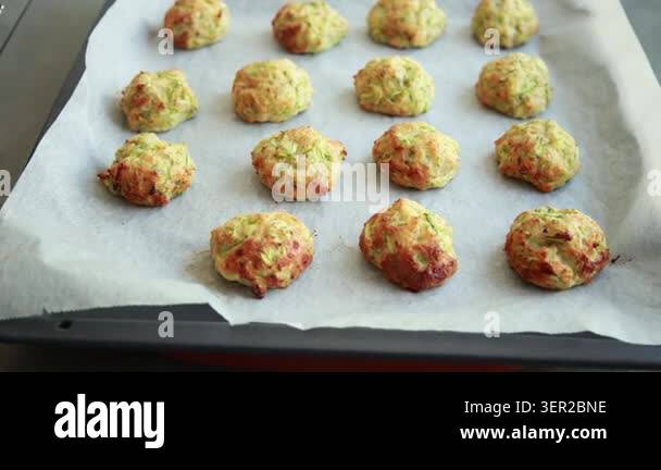 Close-up of golden, crispy baked zucchini tots freshly cooked and ...