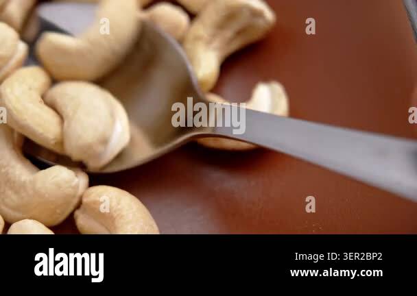 Stainless steel spoon scooping dried cashew nuts. Health food ...