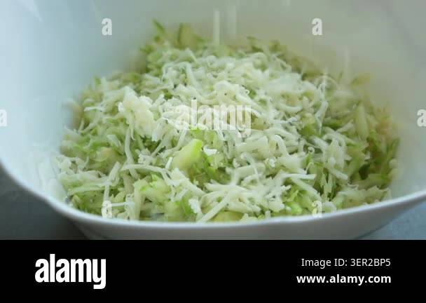 mixing ingredients in a glass bowl to prepare healthy keto zucchini ...