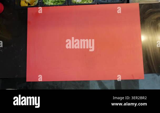 A direct overhead top down video of an authentic chef placing a fresh ...