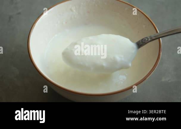 Close-up of hands whisking a simple creamy yogurt sauce with fresh ...