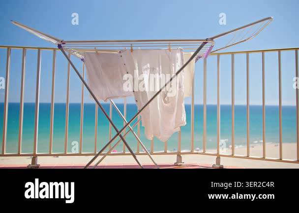 White clothes drying on balcony with sea view and sunny beach resort ...