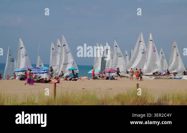 Sant Salvador, Spain, 7 June 2026: Beachgoers and sailing dinghies ...