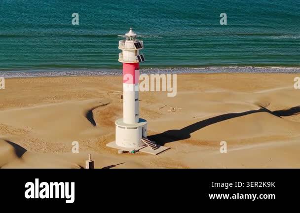 Fangar lighthouse on sandy Mediterranean coastline at Punta del Fangar ...