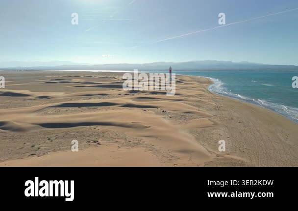 Fangar lighthouse surrounded by coastal dunes at Punta del Fangar in ...