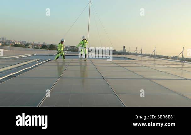 Two engineers in safety clothing with helmet check solar system with ...