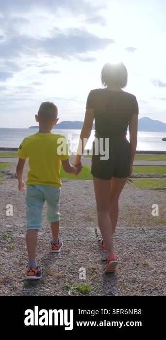 Back view of a young woman and her small son, when they descend by ...