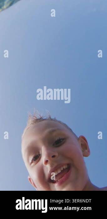 Cute happy kid playing in Adriatic sea while alone looking into water ...