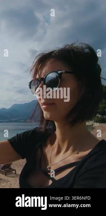 Side view. Side view. Pretty young woman in sunglasses takes selfie on ...